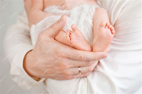 Детские ножки в руках отца. ноги крошечного новорожденного на мужских ...