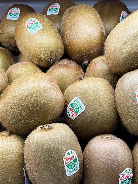 group of kiwi on the shelf of the supermarket display. fruit grocery ...