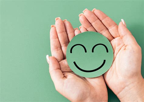 Hände Die Ein Ausgeschnittenes Smileygesicht Aus Pappe Auf Grünem ...