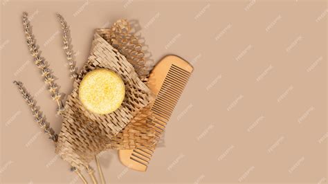 Устойчивый твердый шампунь и деревянная расческа на пастельном фоне из ...
