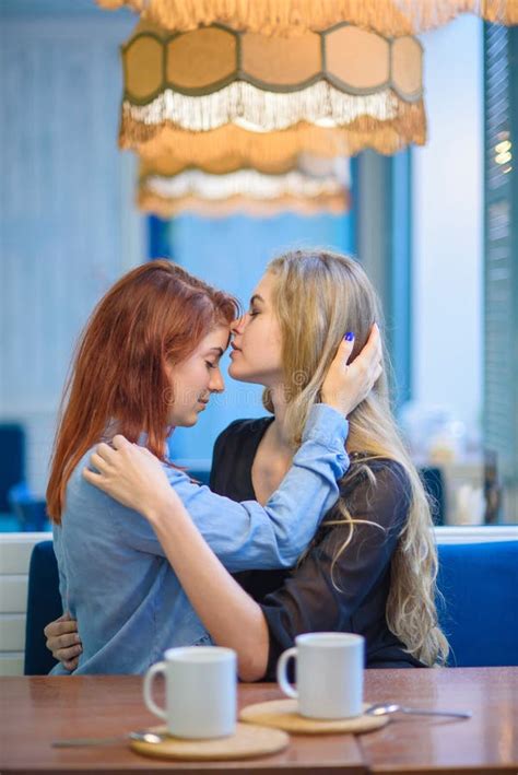 Same-sex Relationships. Happy Lesbian Couple Sitting in a Cafe. Girls Gently Hold Hands and ...