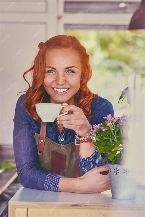 Premium Photo | Portrait of redhead female barista in a small coffee shop.