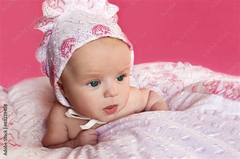 Девочка в чепчике на розовом фоне. Stock 写真 | Adobe Stock