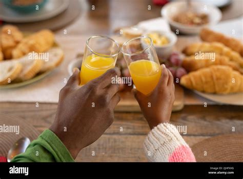 Image of hands of african american father and daughter toasting with ...