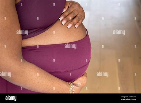 Pregnant woman touching abdomen Stock Photo - Alamy