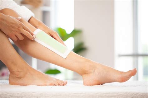 Premium Photo | Beautician waxing woman legs in a spa salon