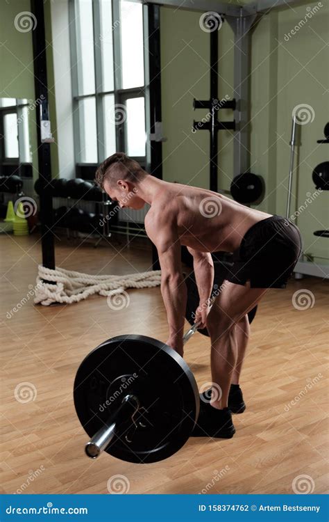 Ein Muskelmann in Sportshorts Und Ein Nackter Torso Steht Im Fitnessraum Und in Halber Umdrehung ...