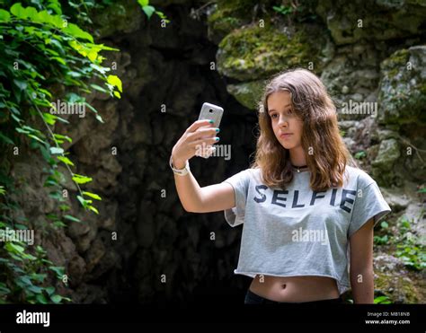 Pretty, teen girl portrait, long hair, outdoors, takes selfie with ...